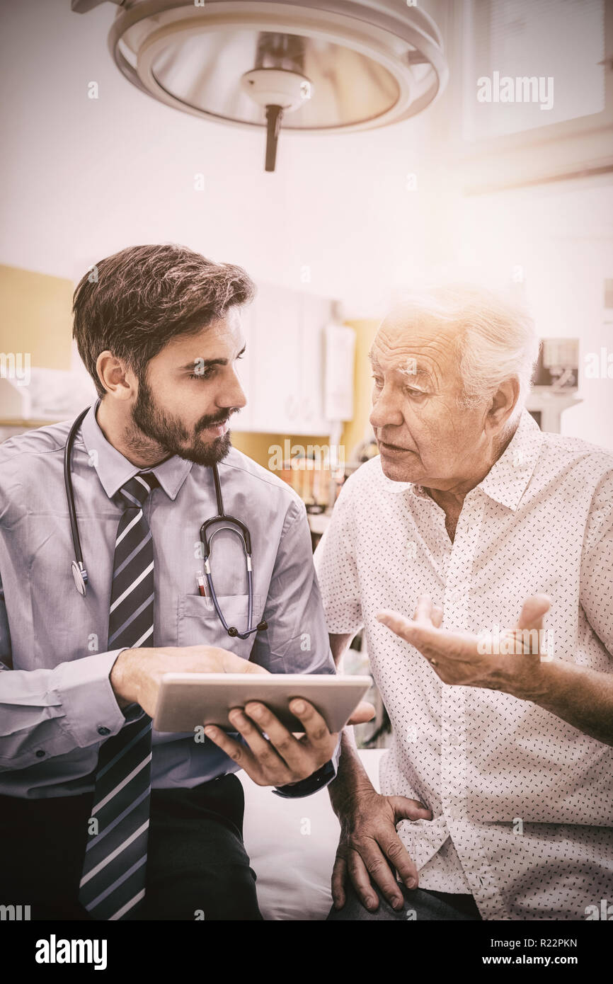 Doctor discussing with patient over digital tablet Stock Photo - Alamy