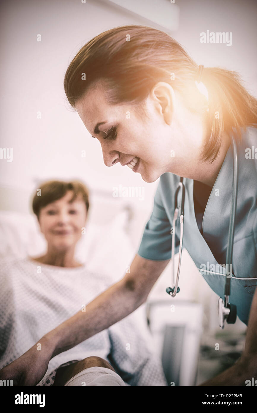 Nurse bandaging leg of patient Stock Photo - Alamy