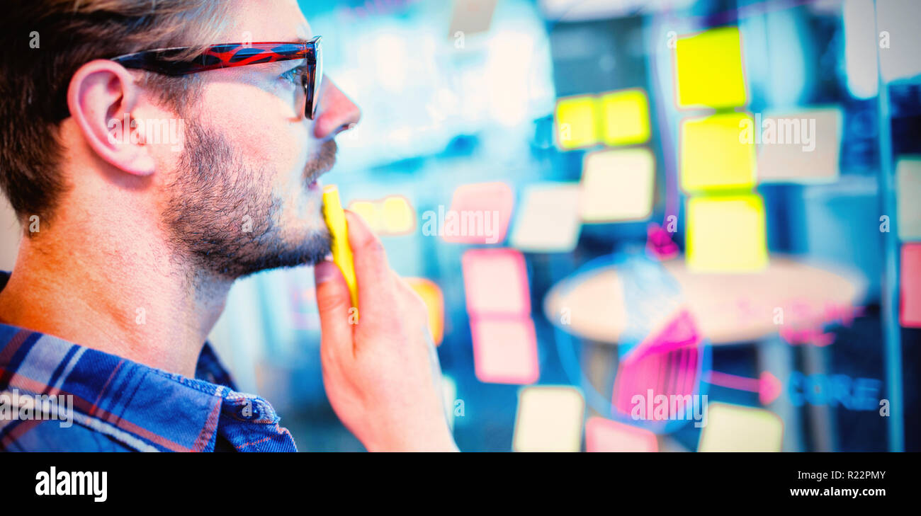 Thoughtful man reading sticky notes on the glass wall Stock Photo - Alamy