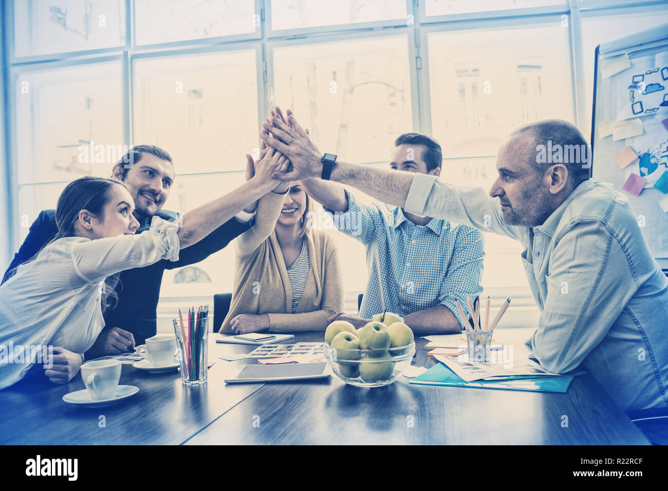 Coworkers giving high-five in meeting room Stock Photo - Alamy