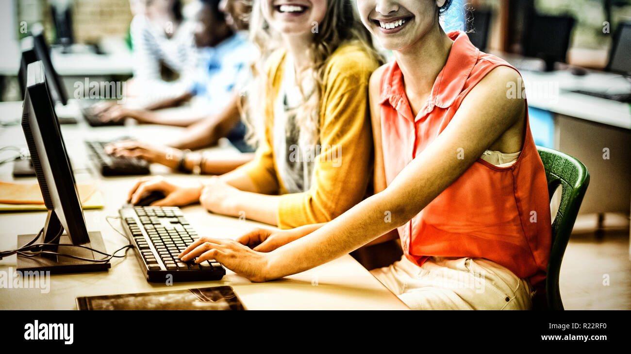 Portrait of a smiling female with students sitting at the college ...
