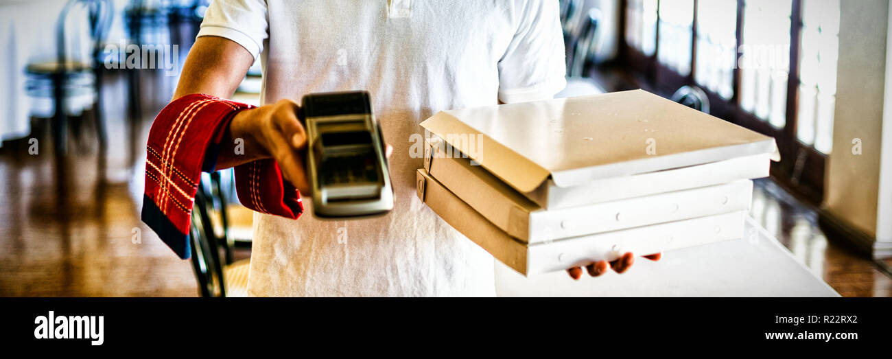 Happy pizza delivery man showing fresh pizza and thumbs up in a ...