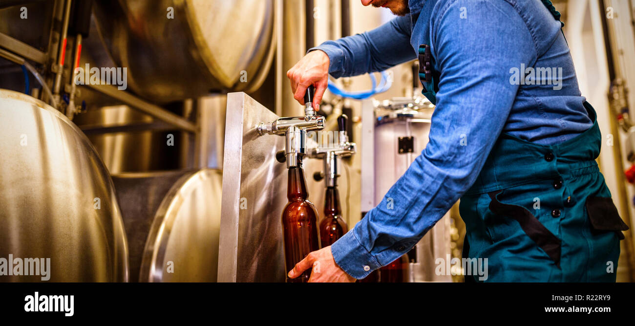 Brewer filling beer in bottle Stock Photo - Alamy