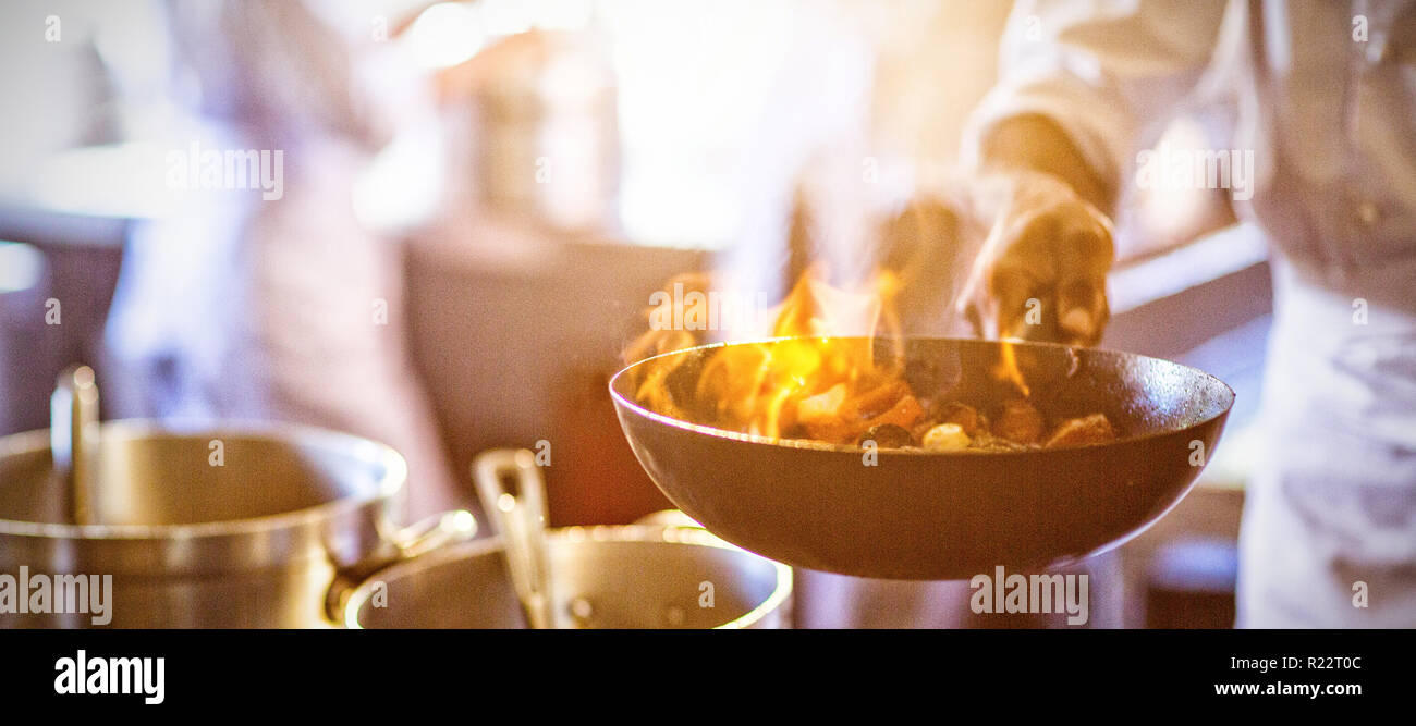 Chef cooking in commercial kitchen Stock Photo - Alamy