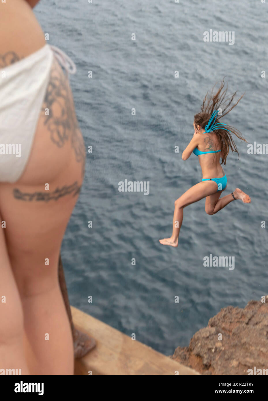 Ka Lae, Hawaii - A teenage girl jumps from a 40-foot cliff into the Pacific Ocean at South Point ...