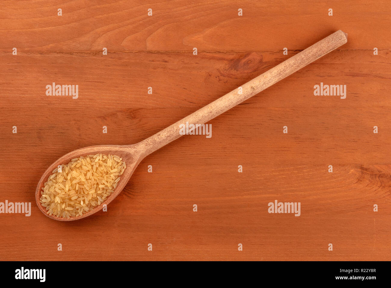 An overhead photo of integral brown rice in a wooden spoon, shot from ...
