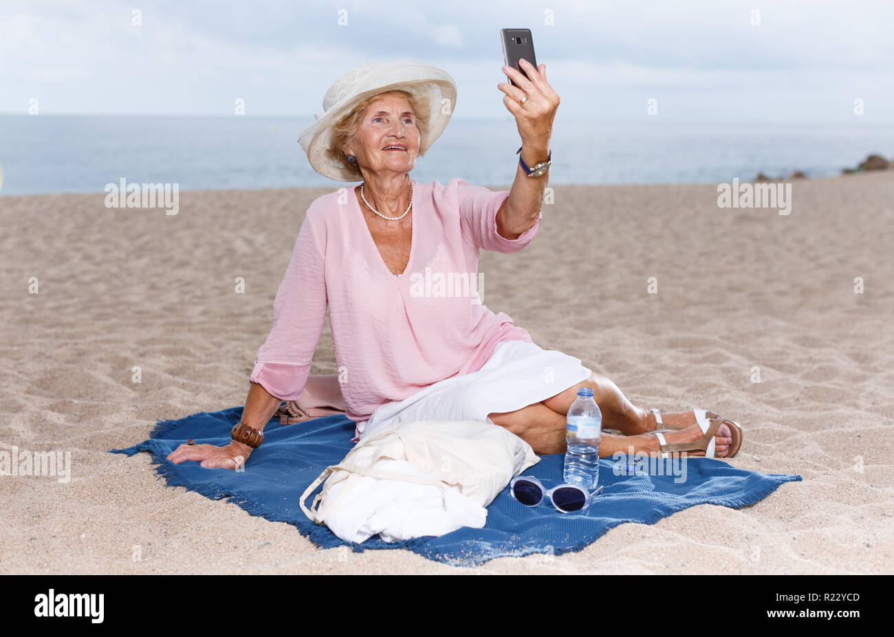 Smiling senior lady relaxing on beach walk and making selfie Stock ...