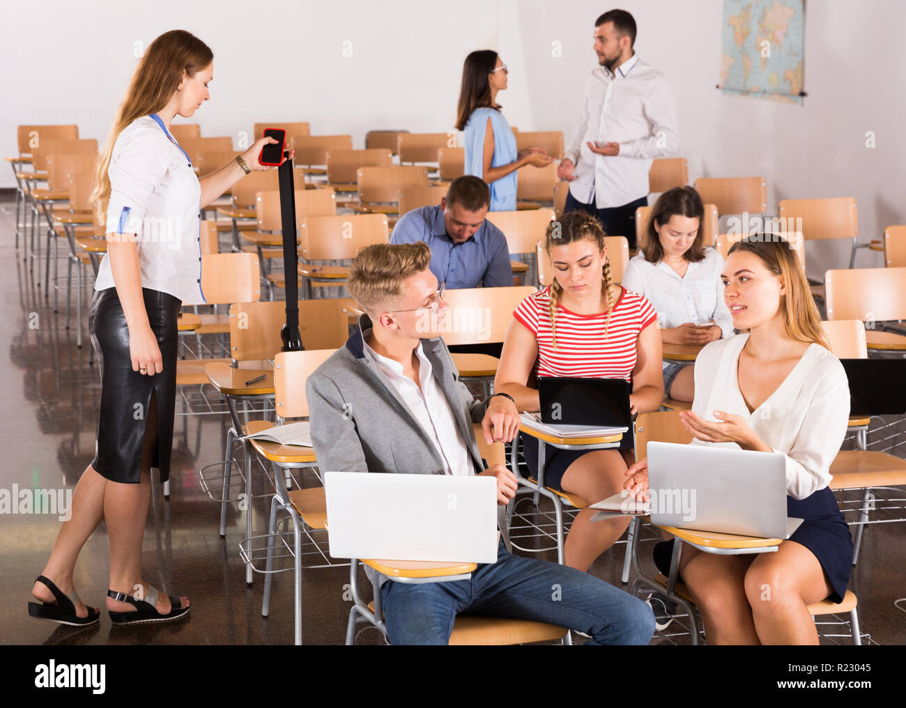 Smiling adult students communicating during recess between lectures in ...
