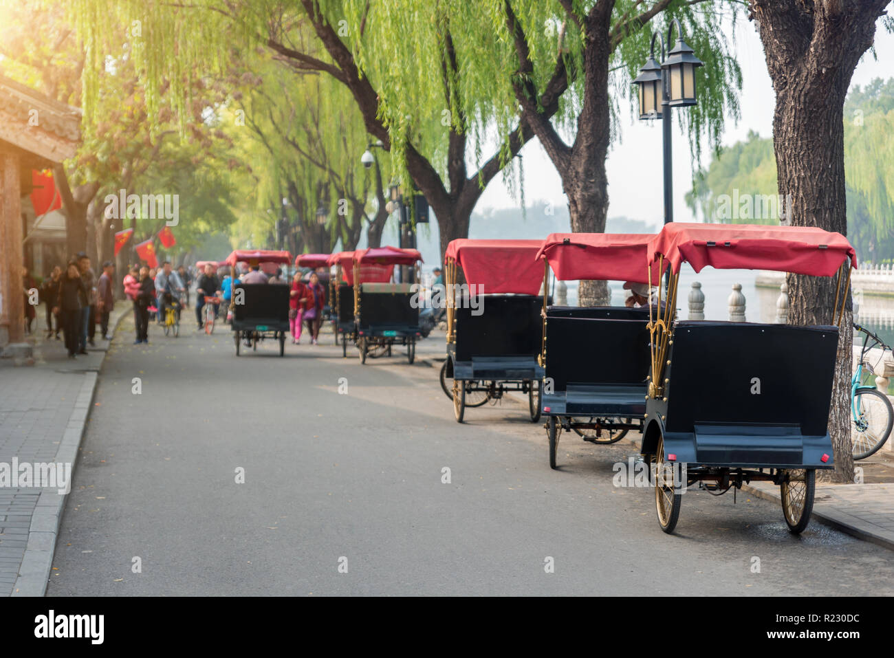 Tourists riding Beijing traditional rickshaw in old China Hutongs in ...