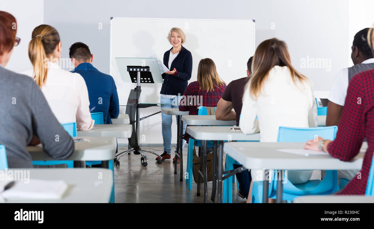 Female speaker giving presentation for adult students in lecture hall ...