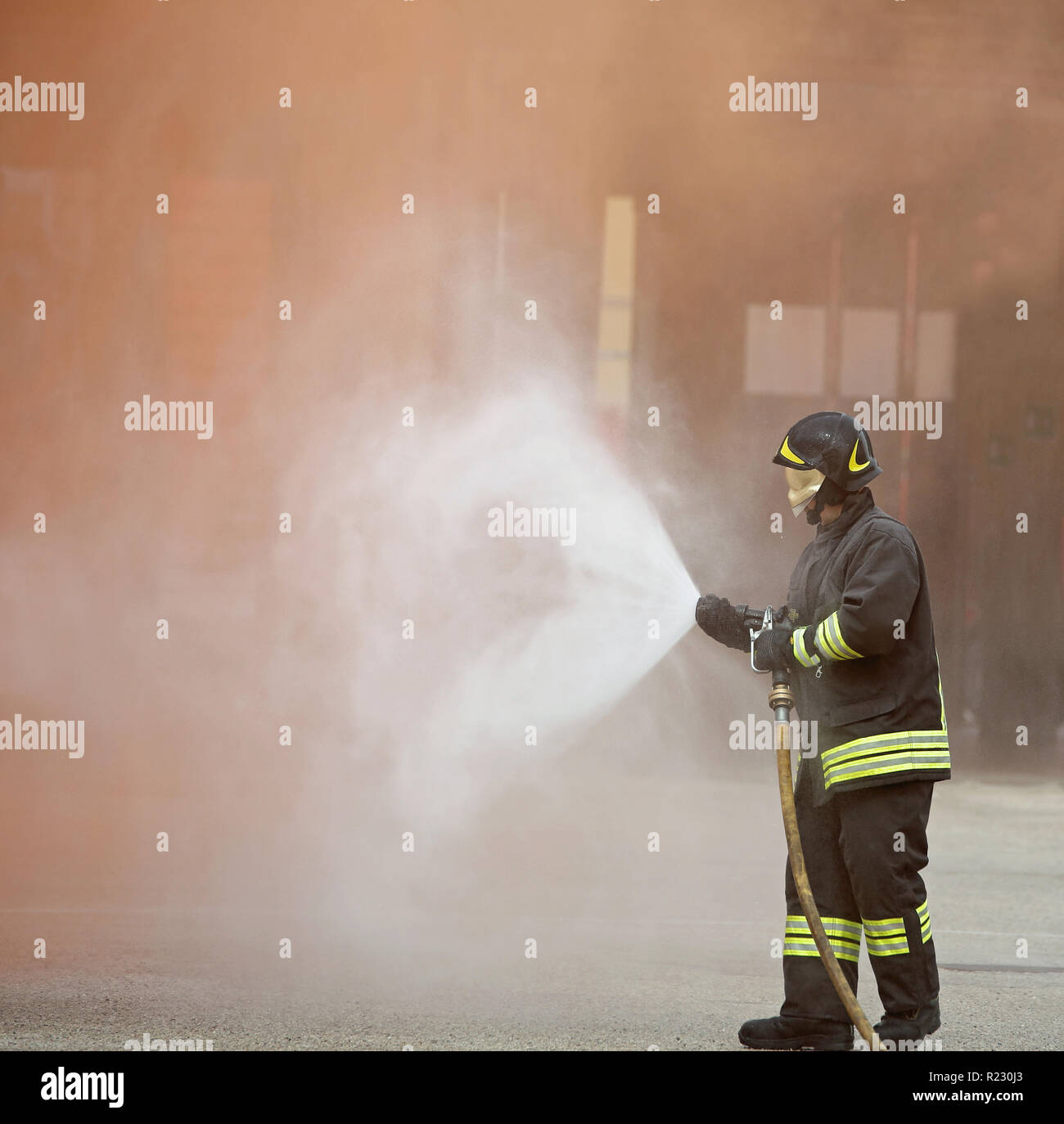 Firefighter extinguishes a large fire with a foam hydrant Stock Photo ...