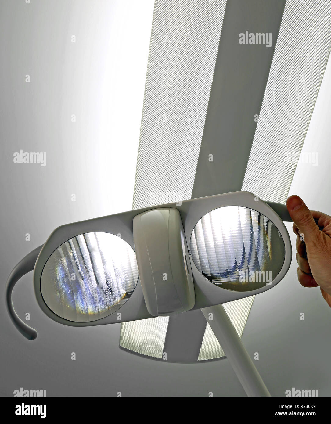 modern lamp of an operating room and the hand of the doctor who adjusts ...