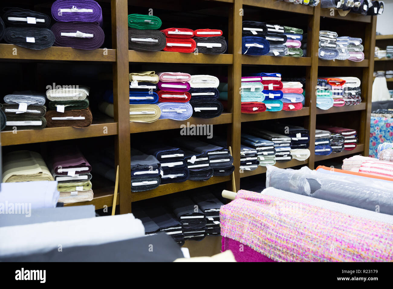 View of cloth rolls of different colors and patterns on shelves in ...