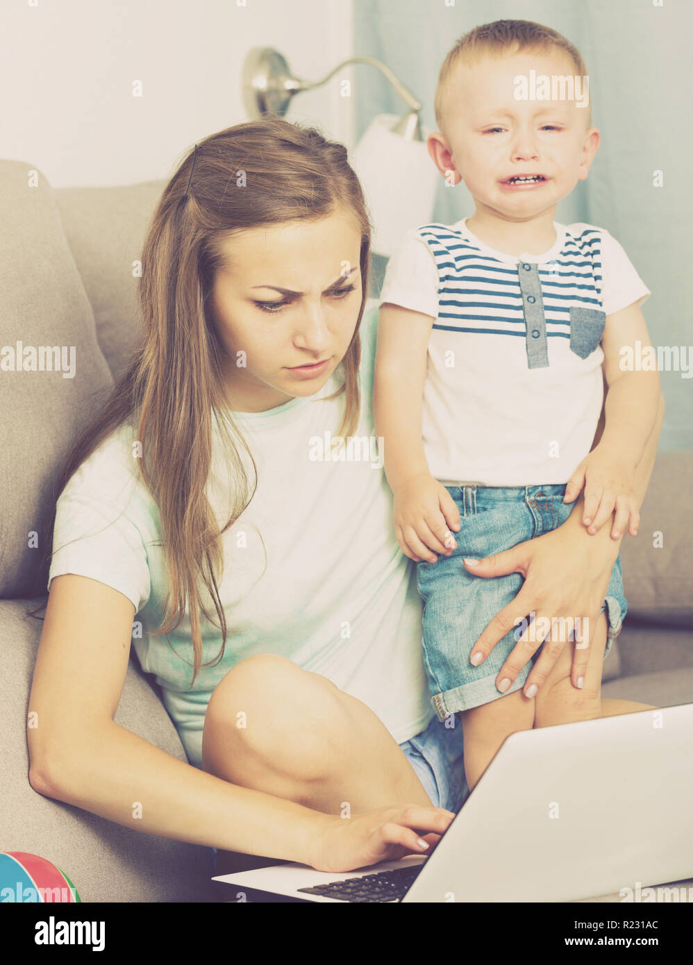 Perplexed woman 24-28 years old is having issue with work while child ...