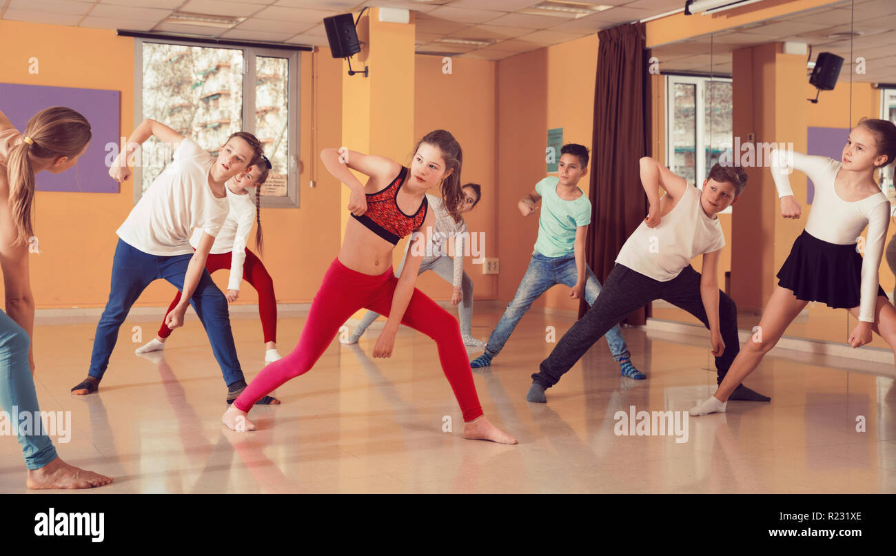 Group of children participating in dance class, following their teacher ...