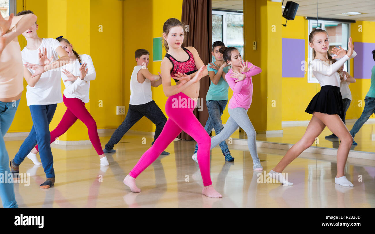 Group of children participating in dance class, following their teacher ...