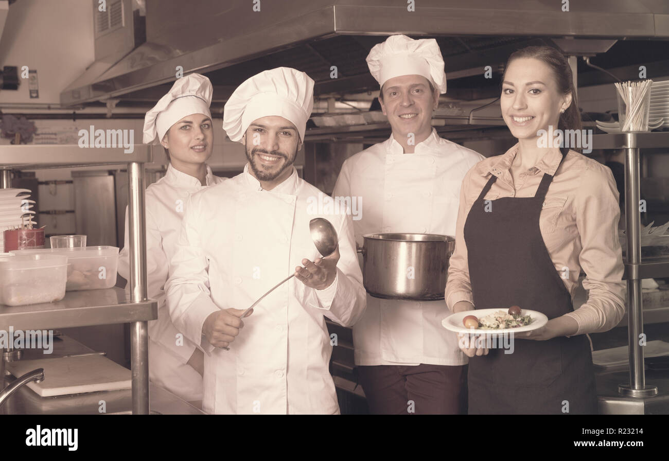 Team of restaurant staff posing together in modern professional kitchen ...