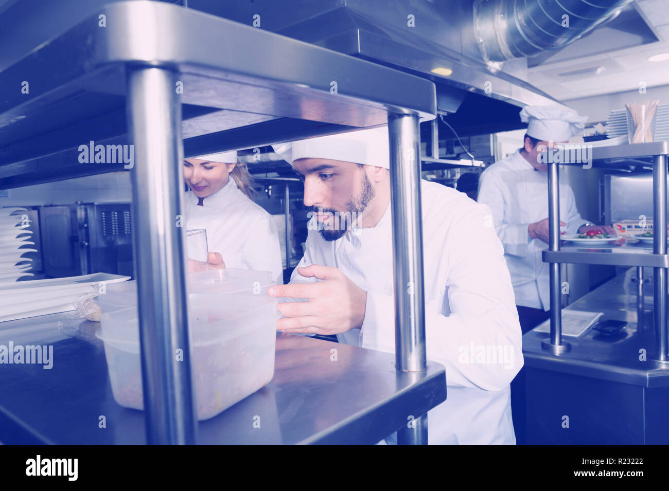 Staff of restaurant with head chef working together in kitchen Stock ...