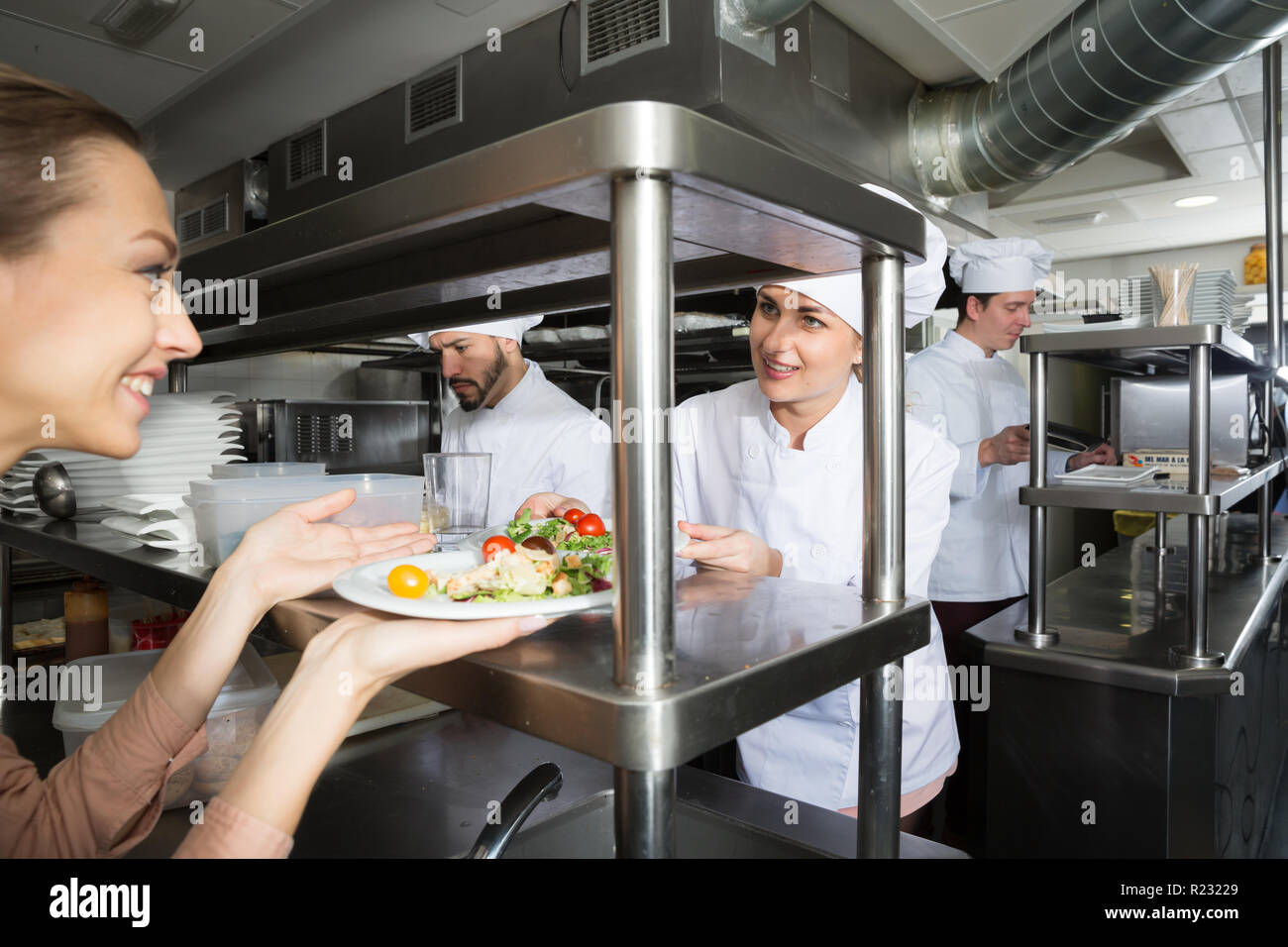 Staff of restaurant with head chef working together in kitchen Stock ...