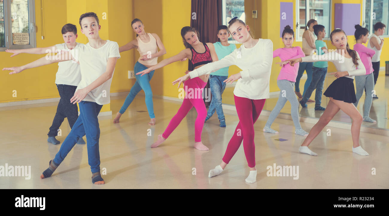 Children dancing synchronous group choreography with female coach in ...