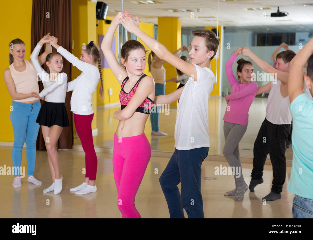 Teenagers in pairs learning to dance active boogie-woogie with female ...