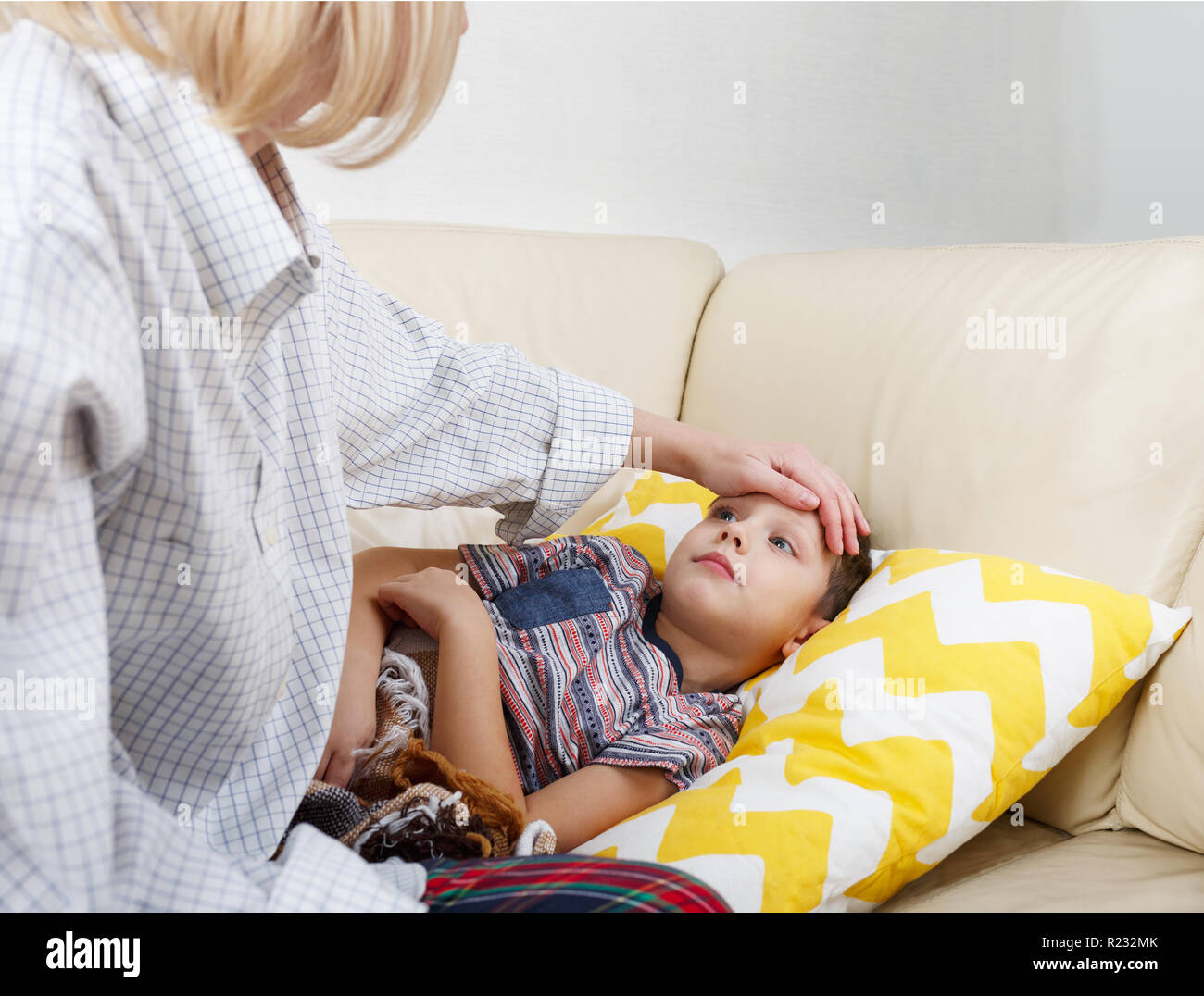 Mom checking the temperature of her ill son Stock Photo - Alamy
