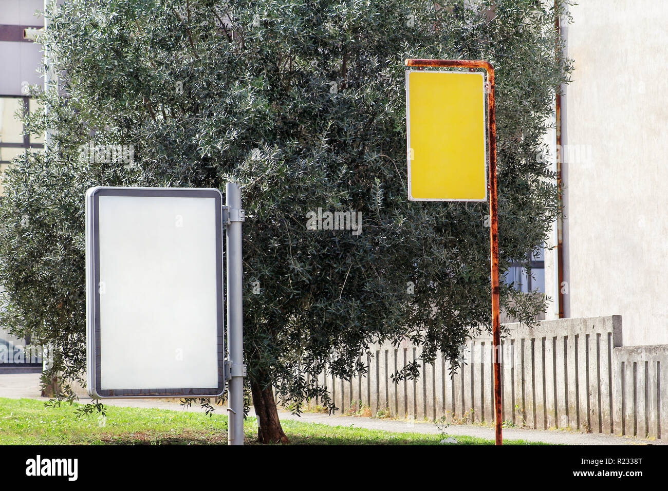 Billboard and yellow advert board in the street city, green plants ...