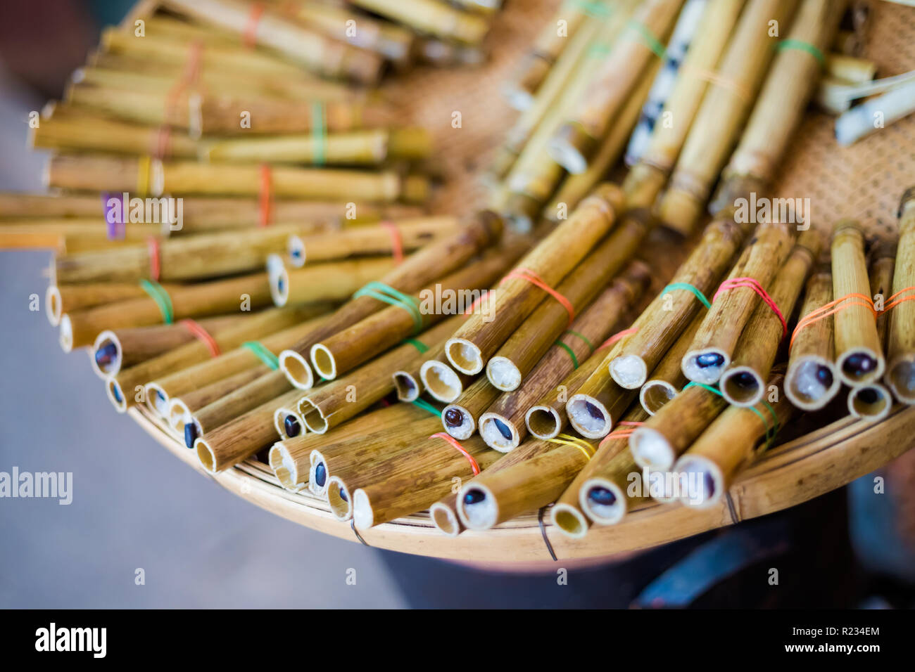 Fresh baked bamboo sticks with black beans and sticky rice on local ...