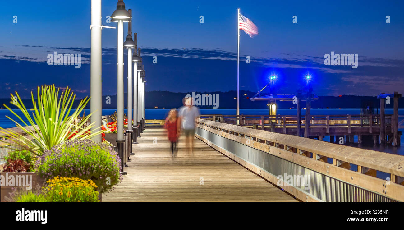 Two people walking on the Tacoma pier at sunset Stock Photo - Alamy