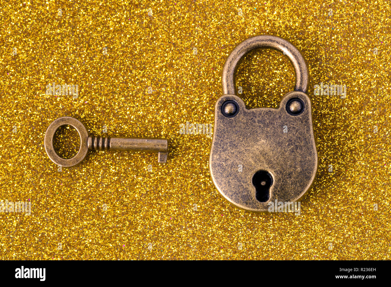 bronze lock and key on a golden background Stock Photo - Alamy