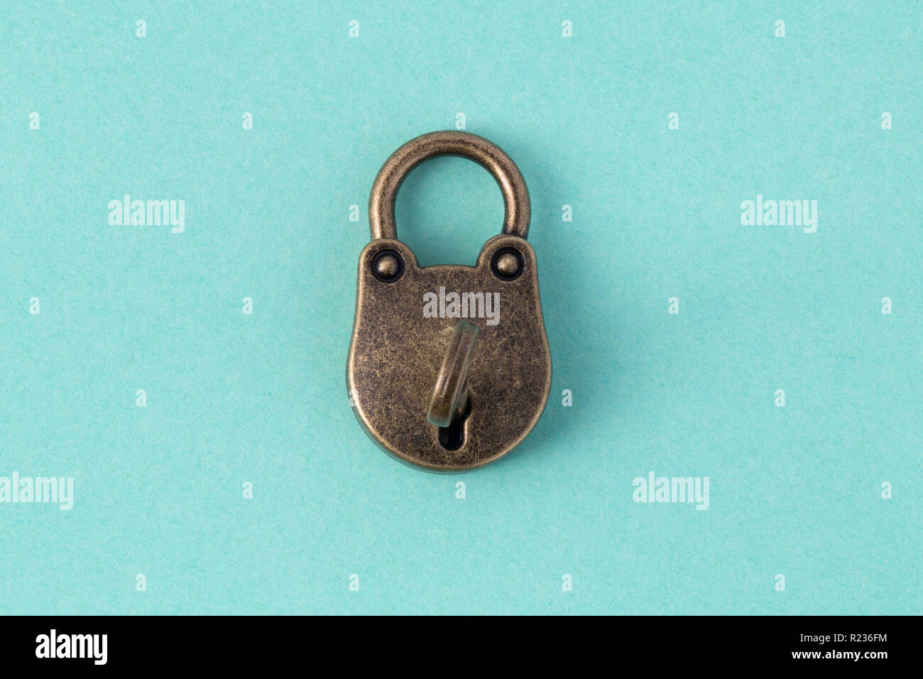 closed bronze lock with key on azure background Stock Photo - Alamy