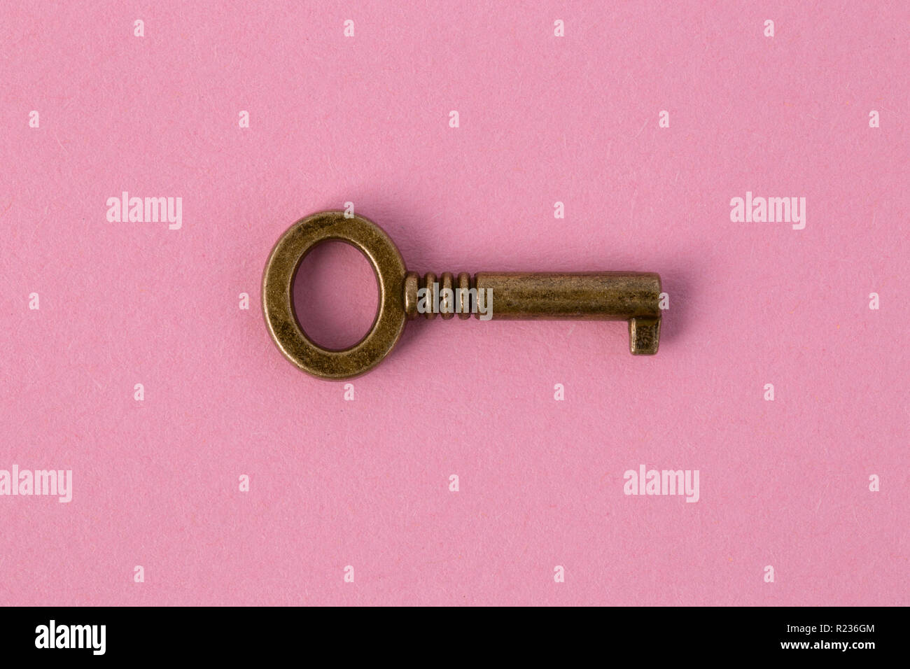 bronze key on gently pink paper, background image Stock Photo - Alamy