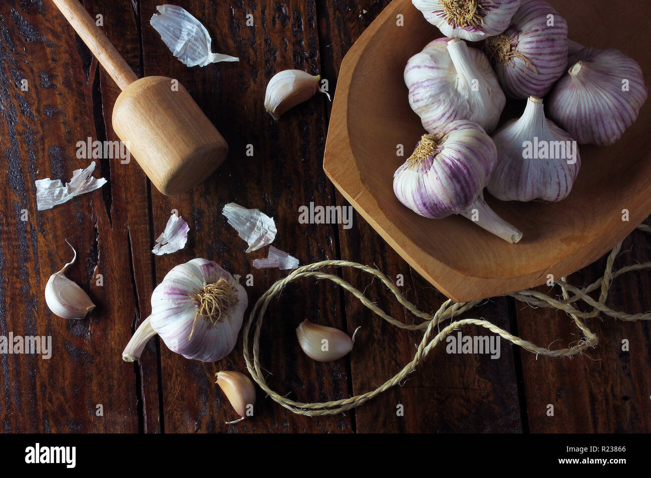 Garlic bulbs inside rustic wooden bowl on rustic wooden table. Closeup ...