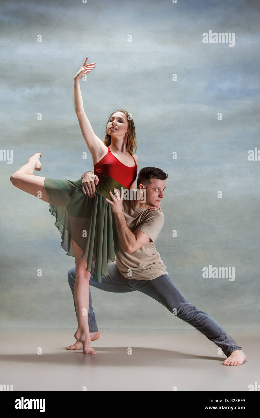 Two people dancing in contemporary stile of ballet at studio on gray ...