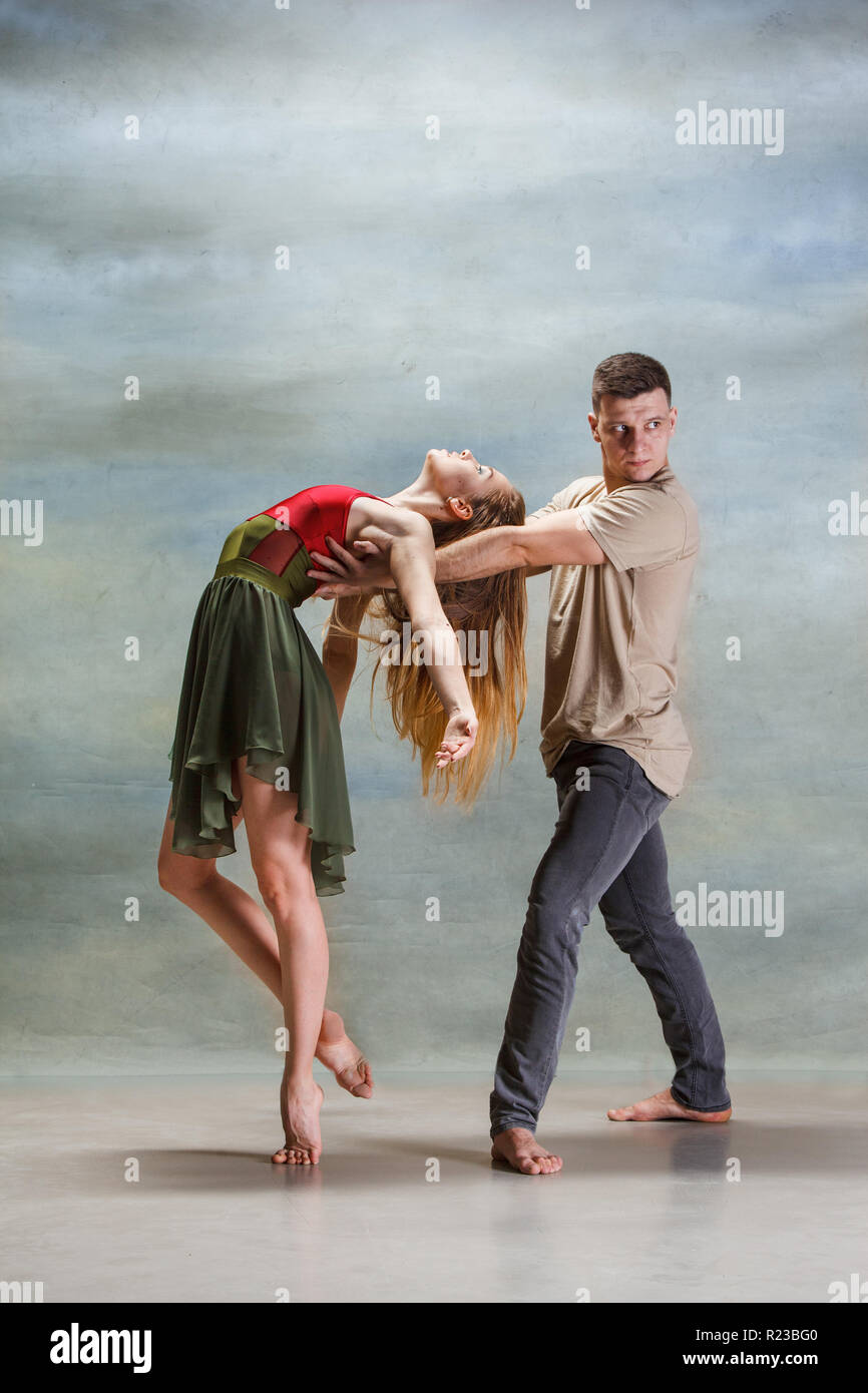 Two people dancing in contemporary stile of ballet at studio on gray ...