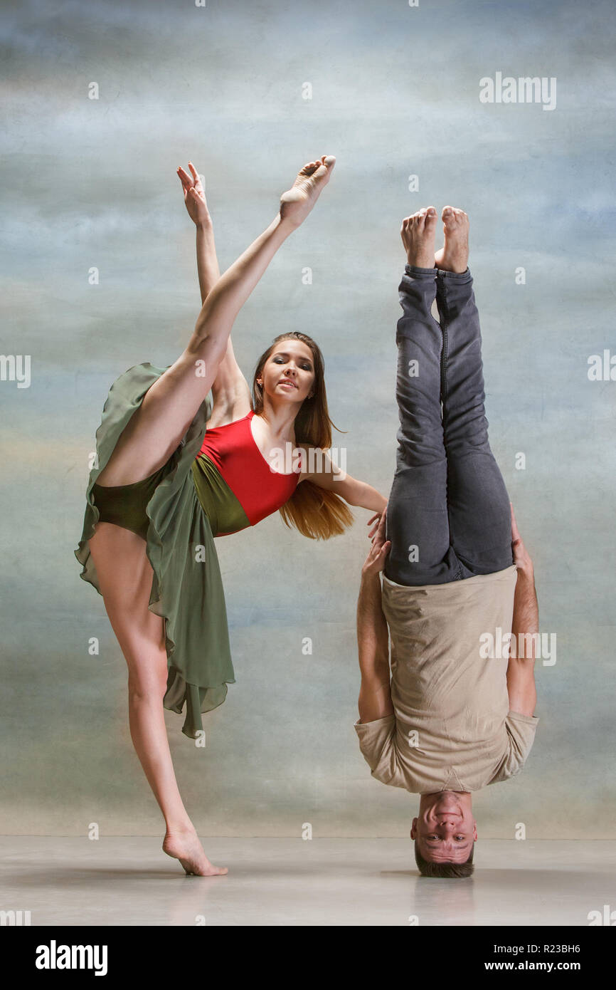 Two people dancing in contemporary stile of ballet at studio on gray ...