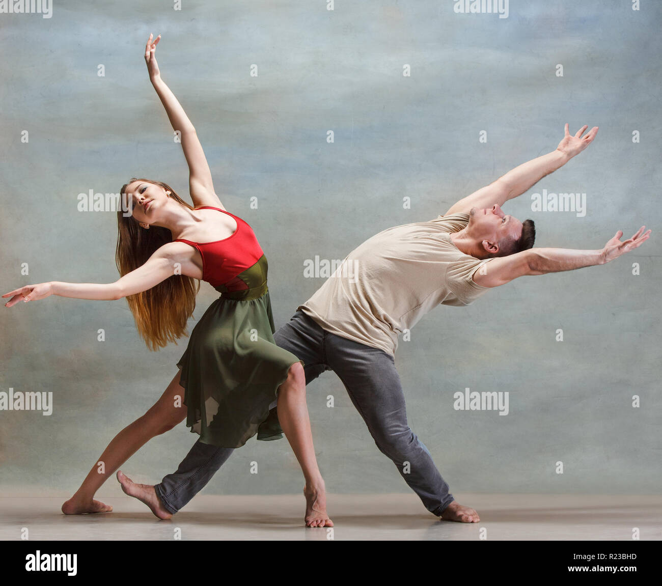 Two people dancing in contemporary stile of ballet at studio on gray ...