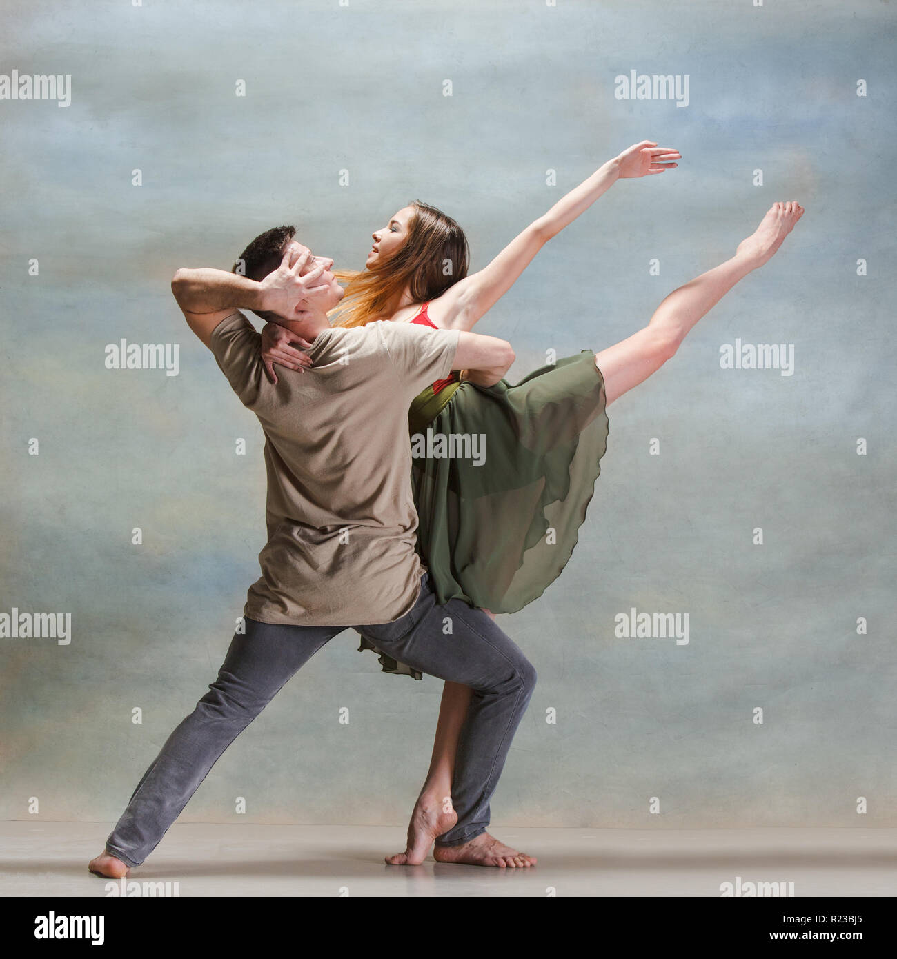 Two people dancing in contemporary stile of ballet at studio on gray ...