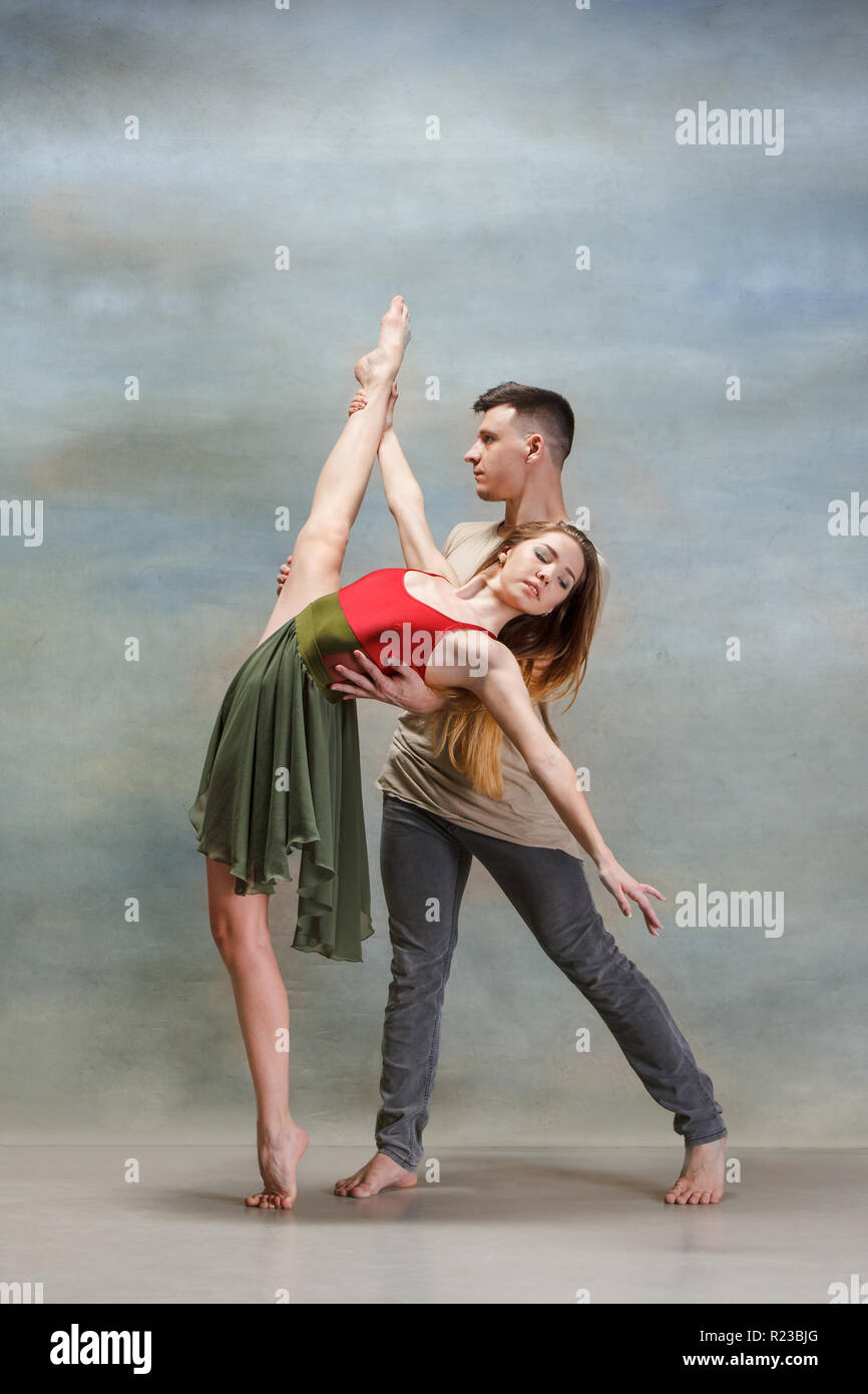 Two people dancing in contemporary stile of ballet at studio on gray ...
