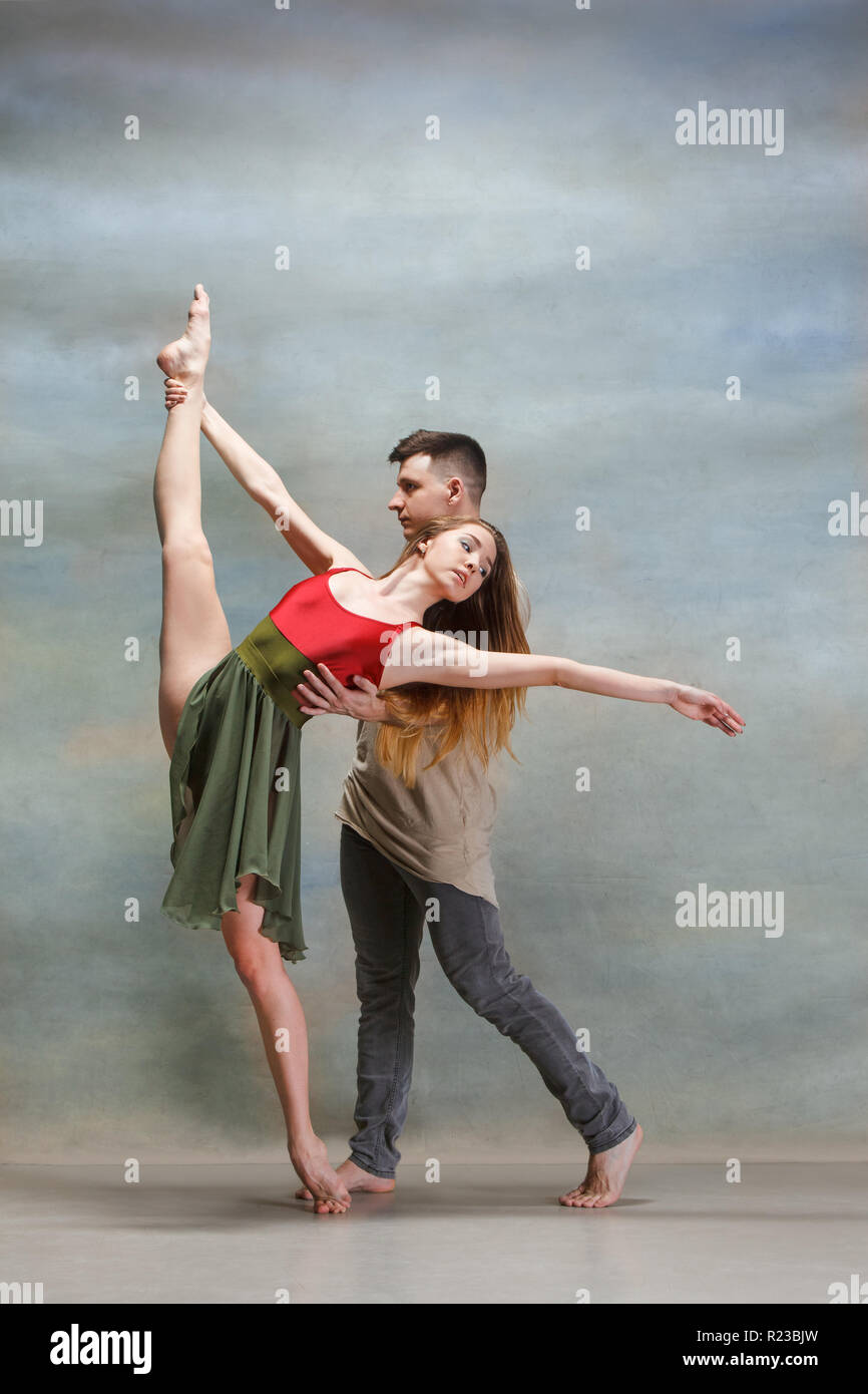 Two people dancing in contemporary stile of ballet at studio on gray ...