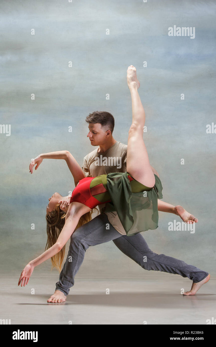 Two people dancing in contemporary stile of ballet at studio on gray ...