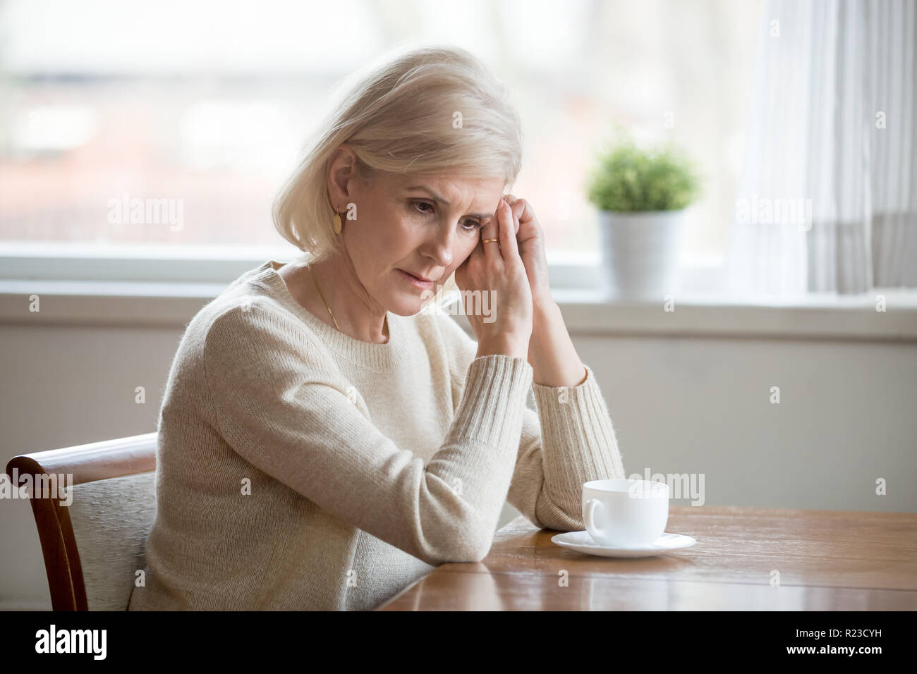 Distracted senior sitting at table hi-res stock photography and images - Alamy