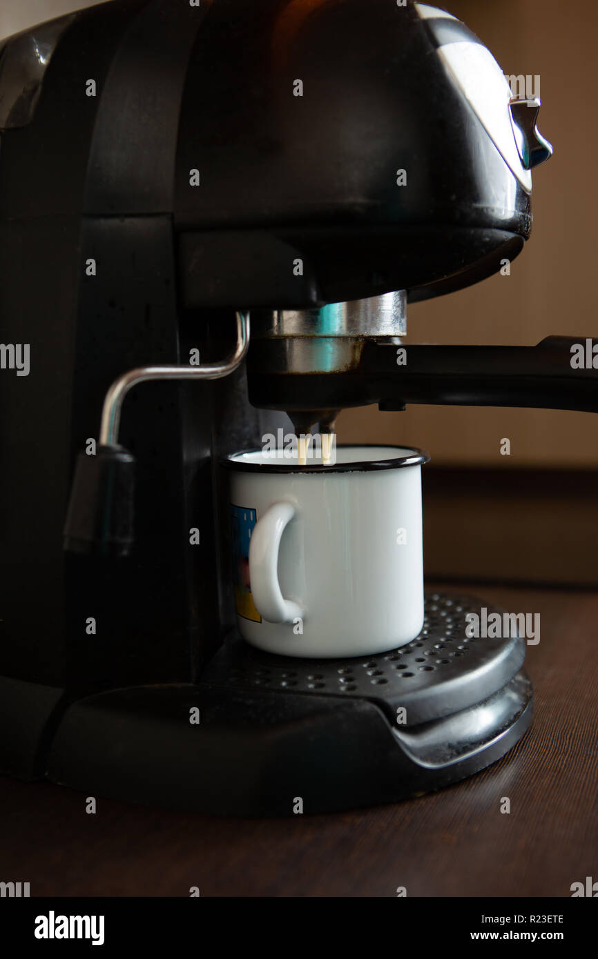 Image of pouring coffee from coffee machine into mug Stock Photo - Alamy