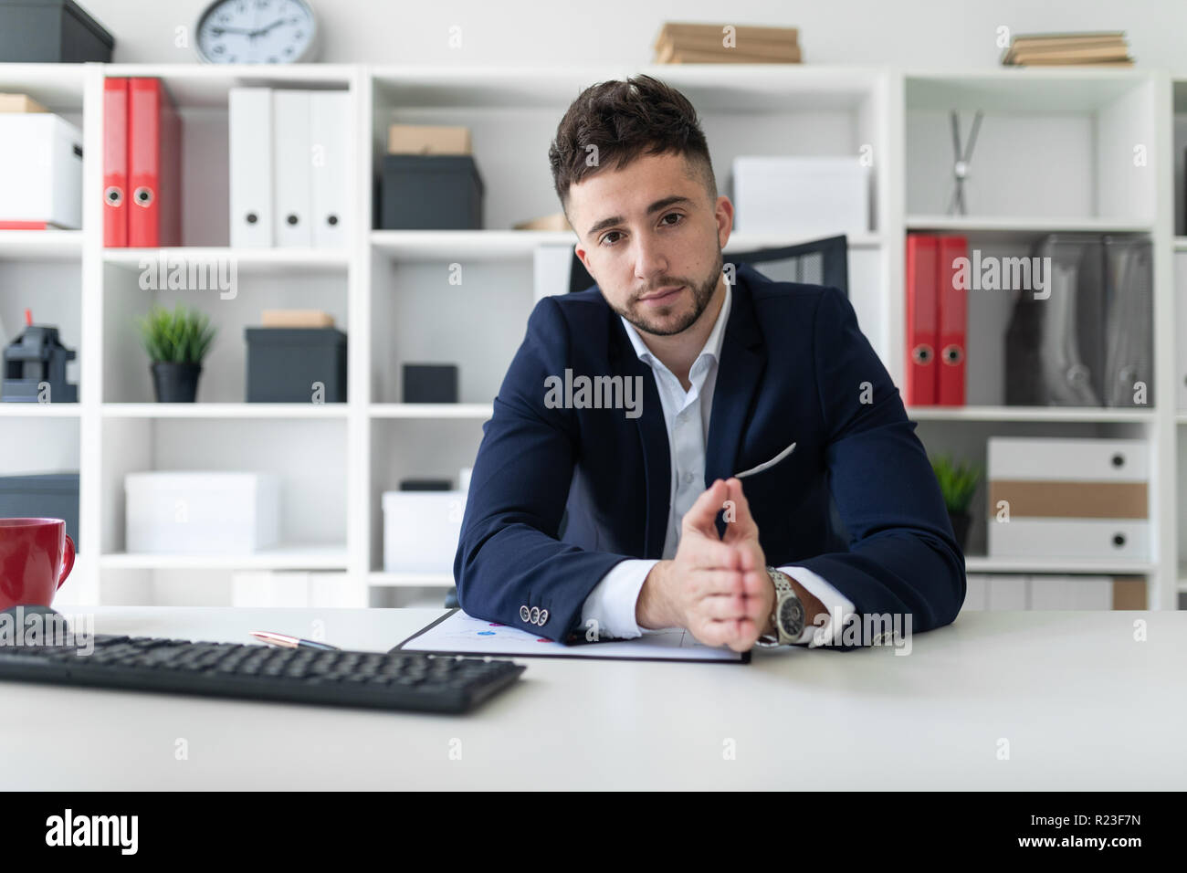 A young man sitting in the office at a computer Desk and working with ...