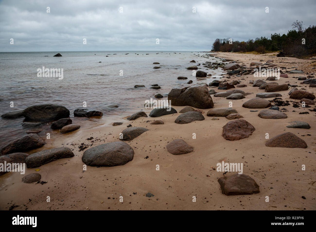 rocky coastline in Latvia with flow water in the sea and large rocks in ...