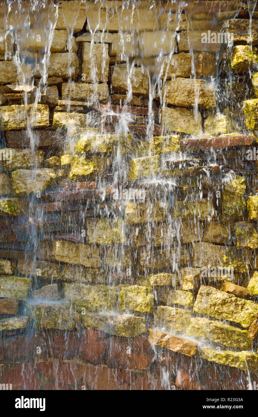 Water flows through the stone wall.It is a beautiful miniature ...