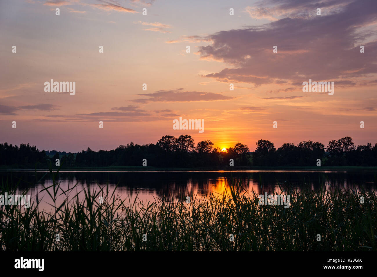 colorful sunset on the lake with water reflections and dramatic storm ...