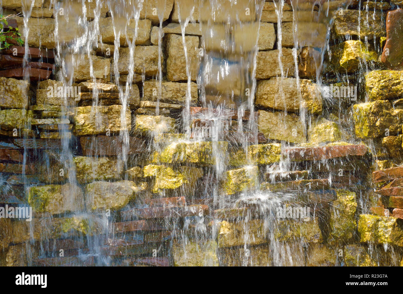 Water flows through the stone wall.It is a beautiful miniature ...