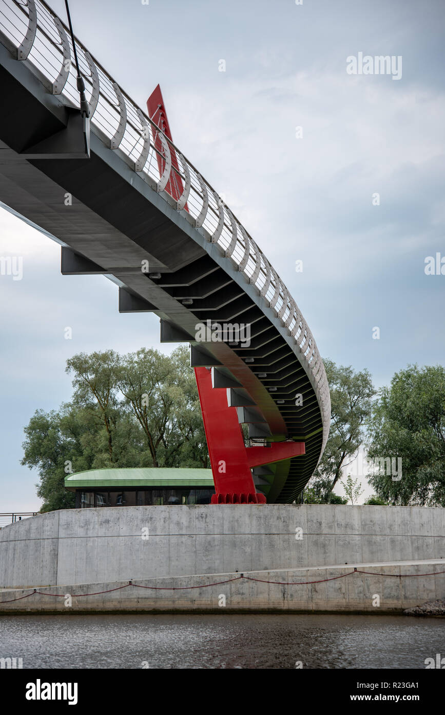 wooden and composite material foot bridge over water in green summer ...