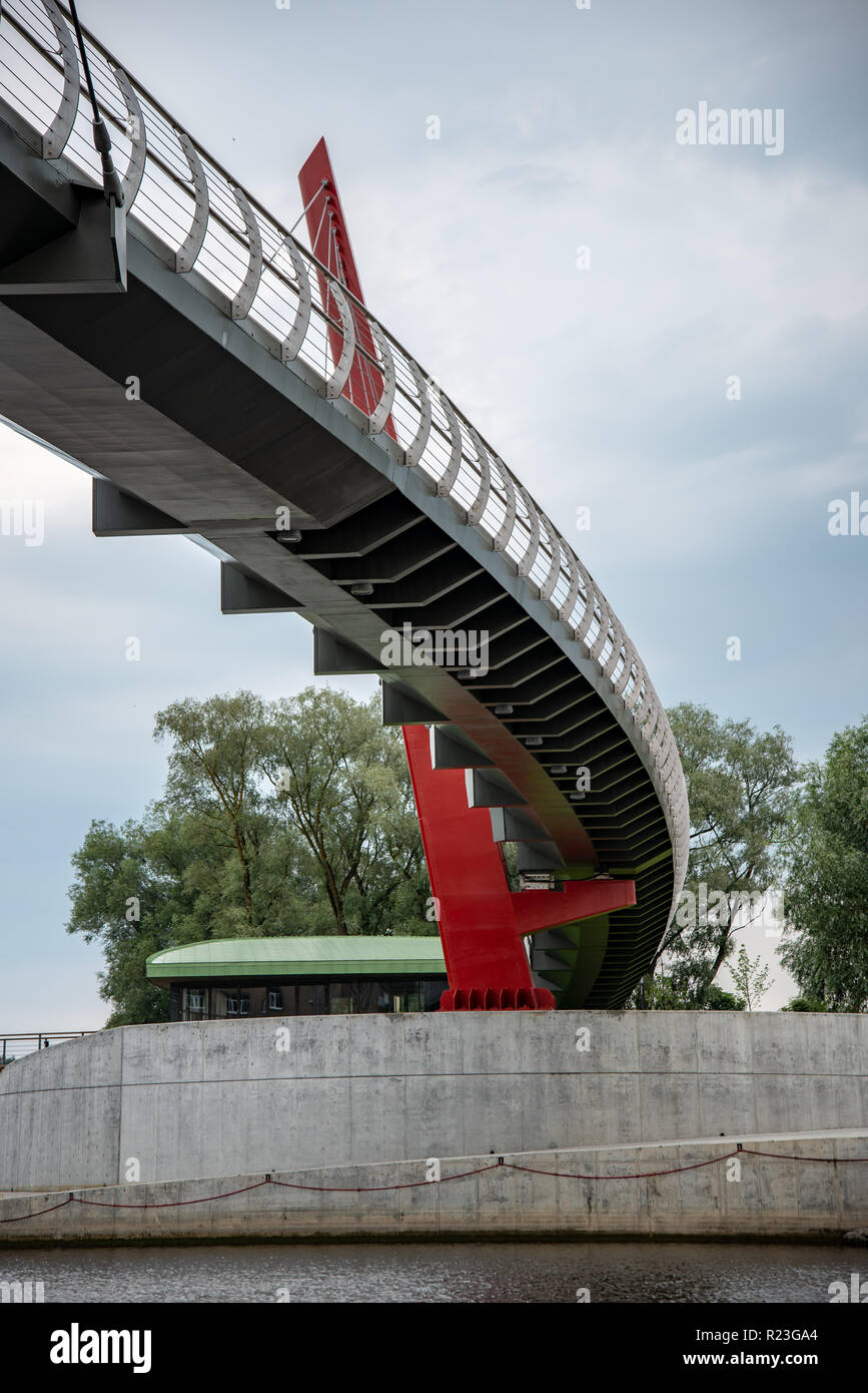 wooden and composite material foot bridge over water in green summer ...